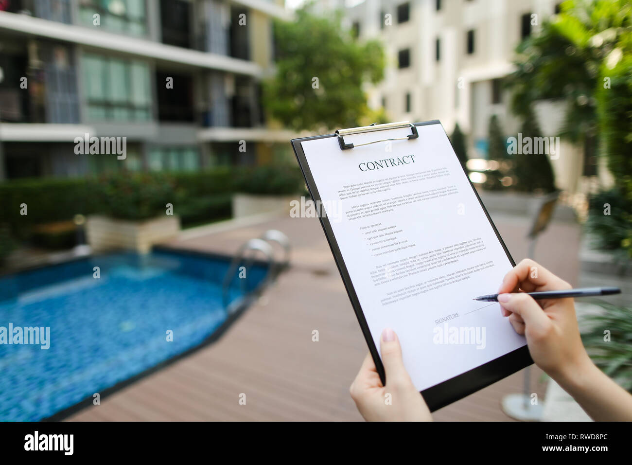 close portrait of woman signs contract on background of building Stock ...
