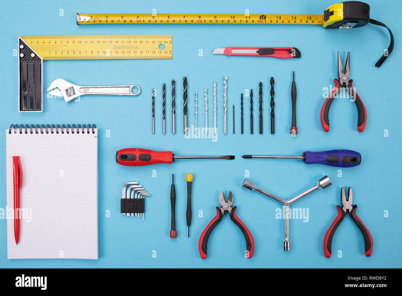 set of metalwork tools with notebook and pen on colorful background ...