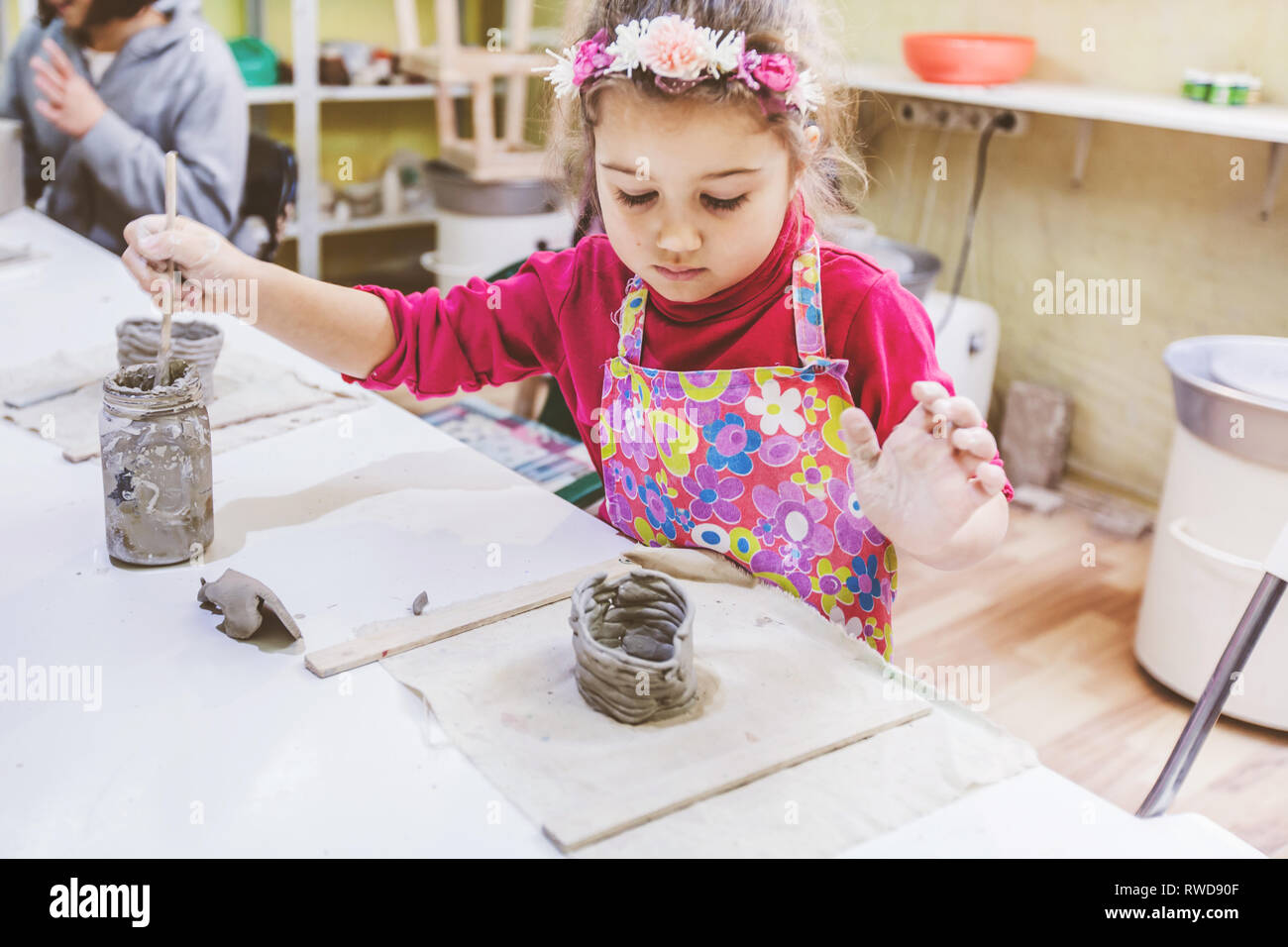 Child pottery workshop, little girl working with clay, creative ...
