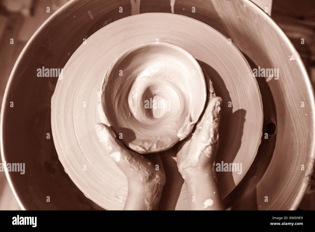 hands of young artist shaping clay on pottery wheel at workshop in ...