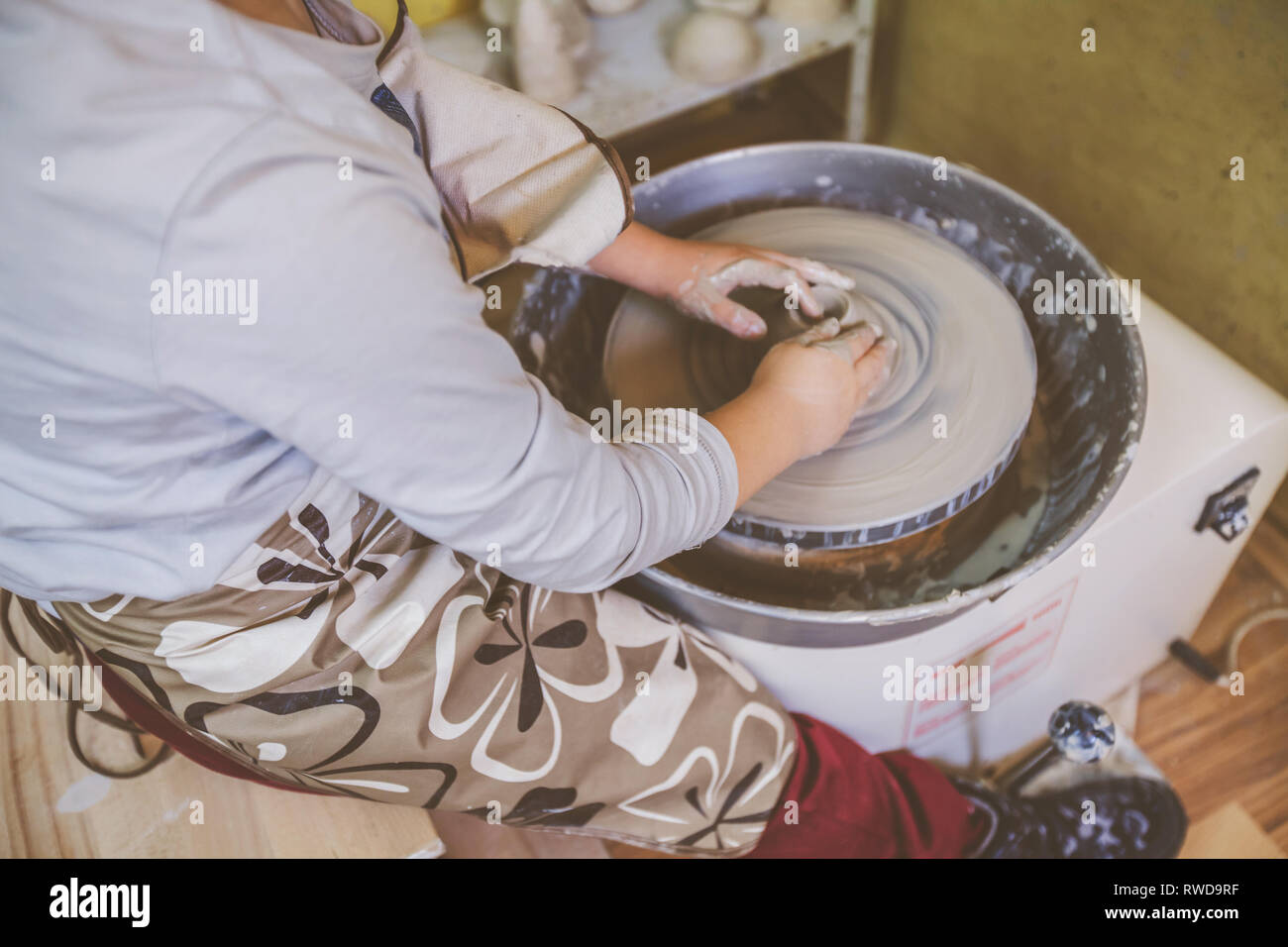 hands of young artist shaping clay on pottery wheel at workshop in ...