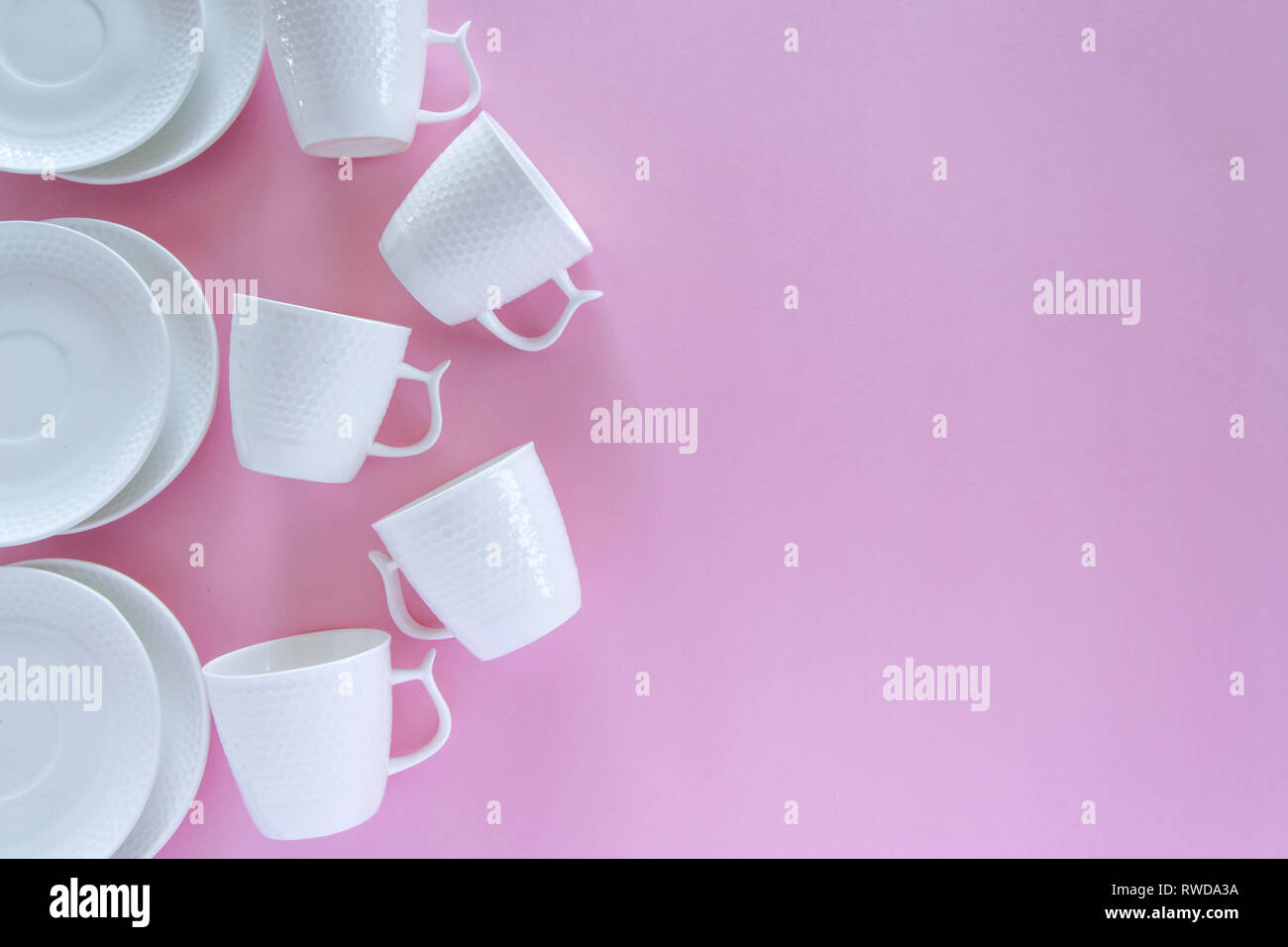Overhead flat lay view of white clean tableware on pink background ...