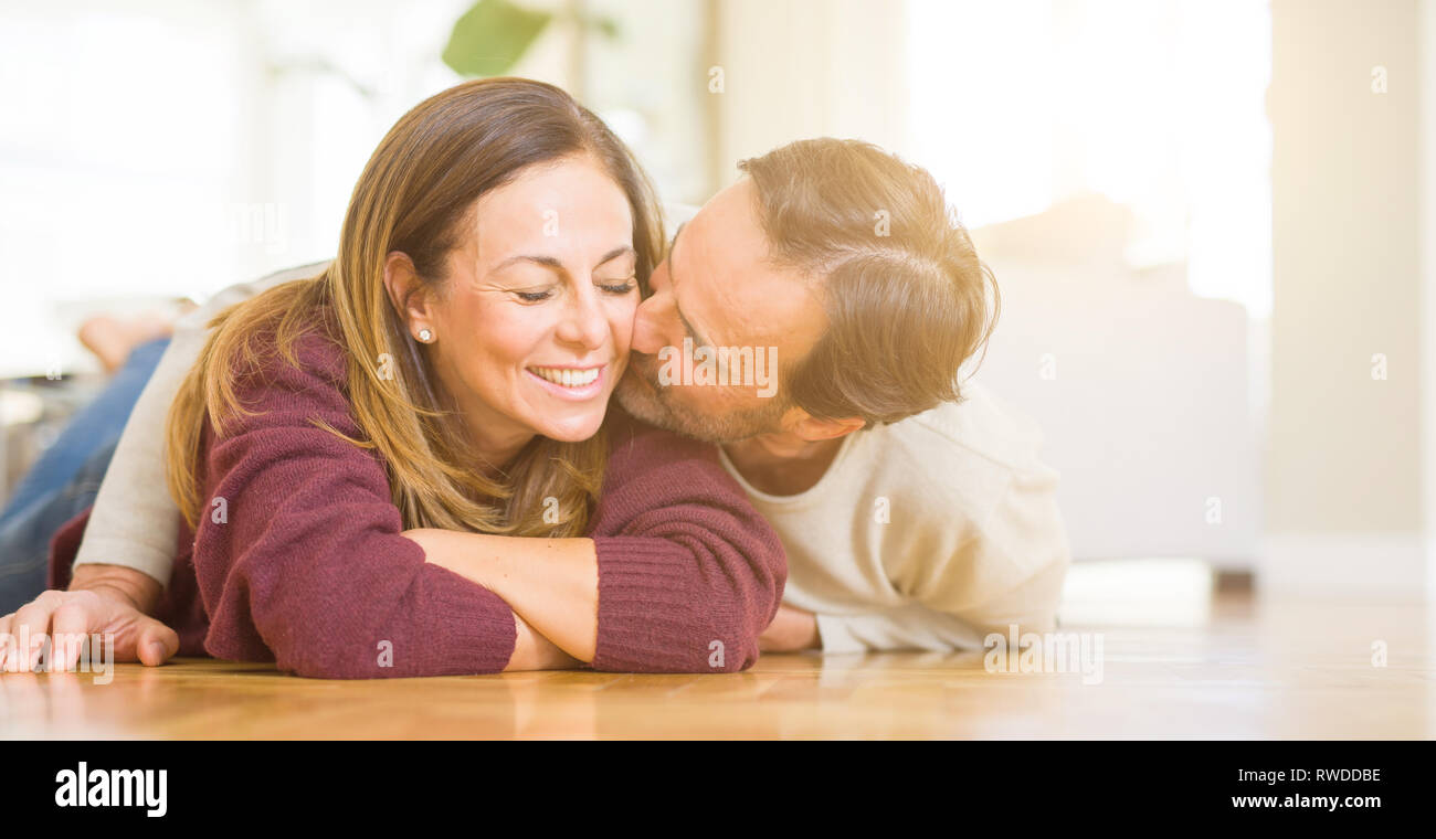 Beautiful romantic couple sitting together on the floor kissing in love ...