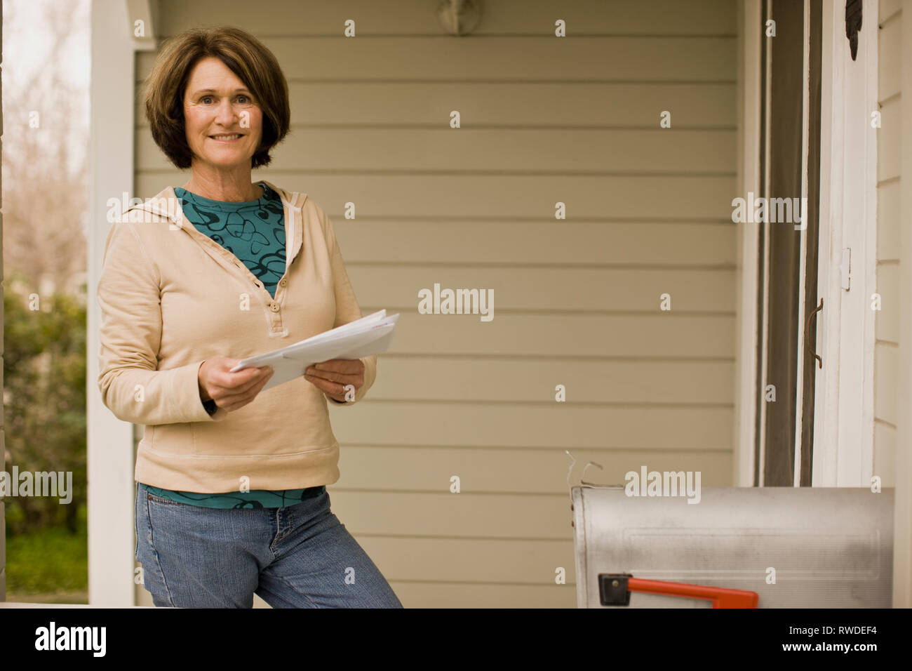 A woman checking her mailbox Stock Photo - Alamy
