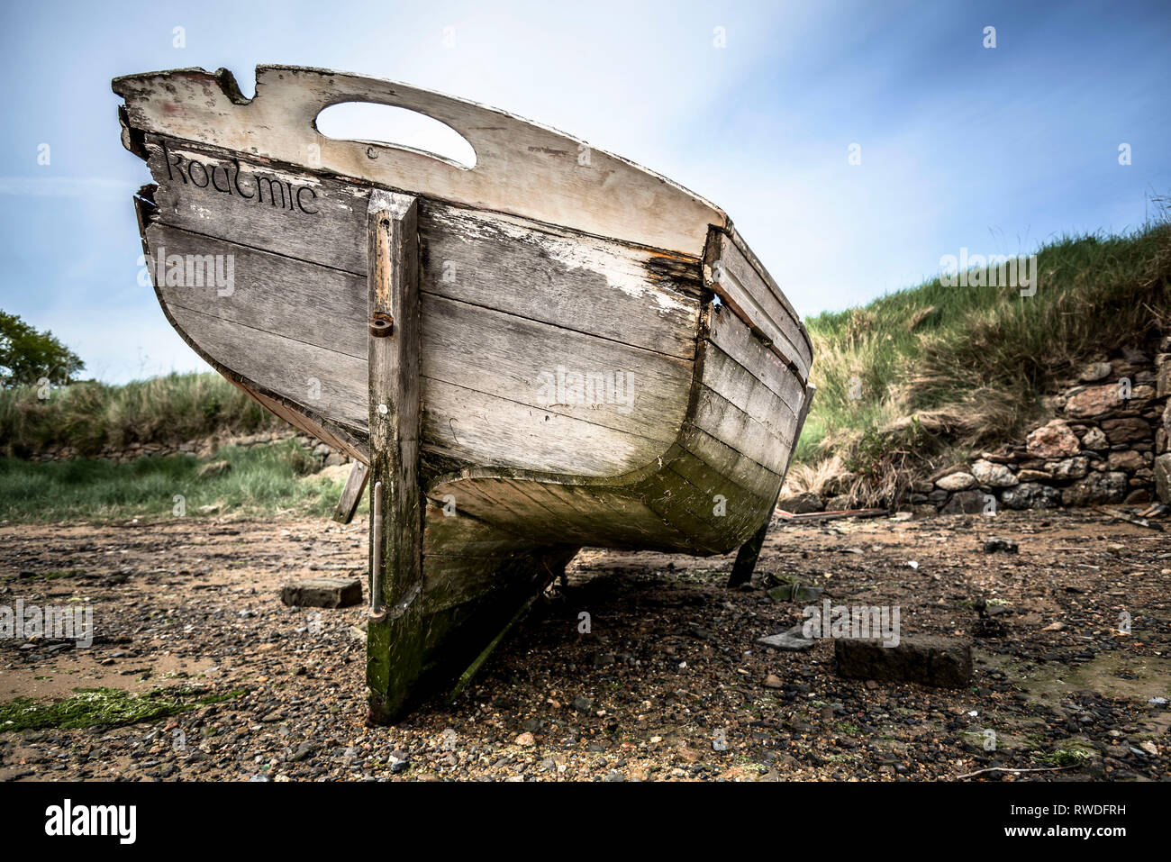 An old boat discarded on a beach Stock Photo - Alamy