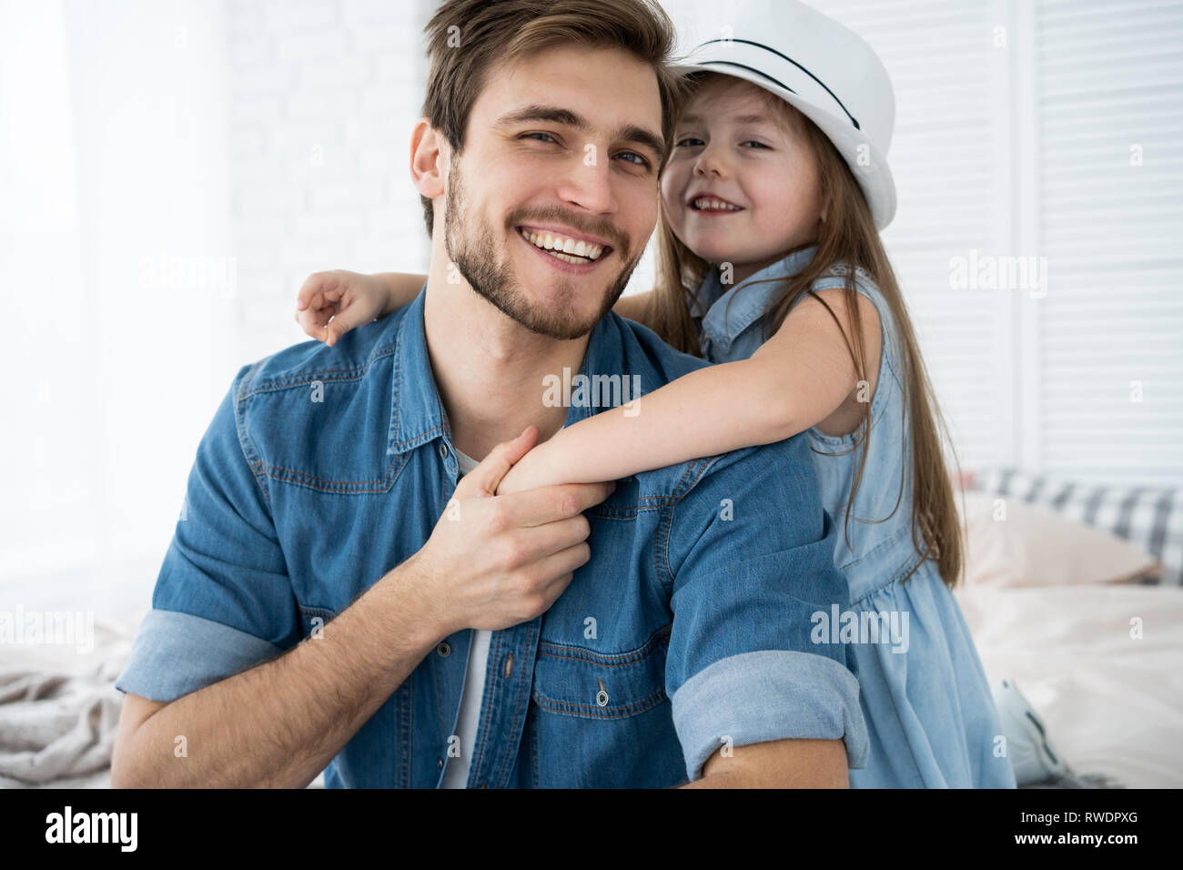 Portrait of handsome father and his cute daughter hugging, looking at ...