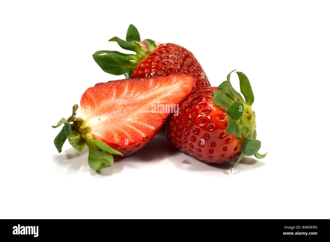 Two whole strawberry fruits and half isolated on white background Stock ...