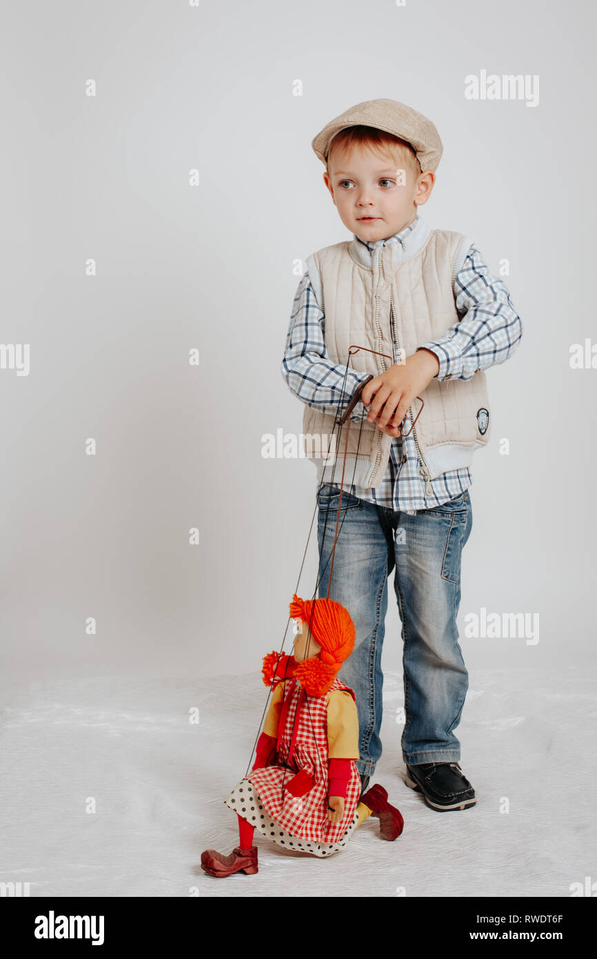 A little boy is standing and playing with a puppet doll Stock Photo - Alamy
