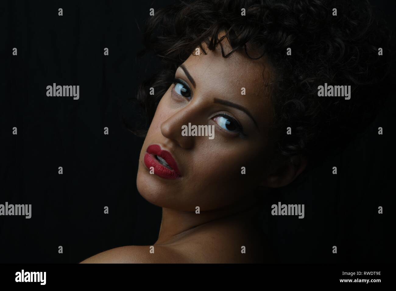 Beautiful mixed race female model in moody studio portrait session ...