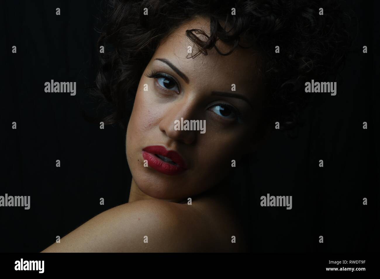 Beautiful mixed race female model in moody studio portrait session ...