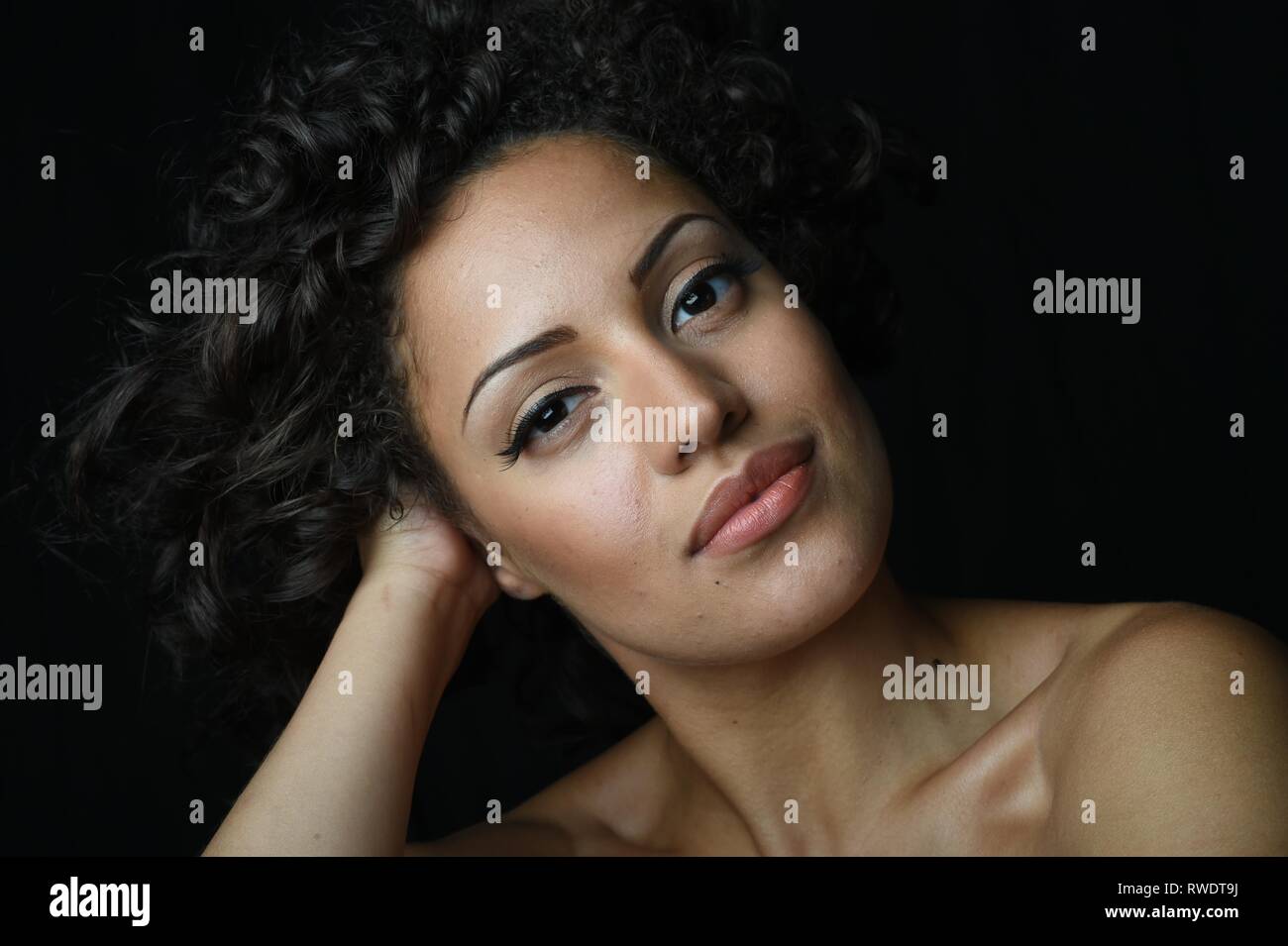 Beautiful mixed race female model in moody studio portrait session ...