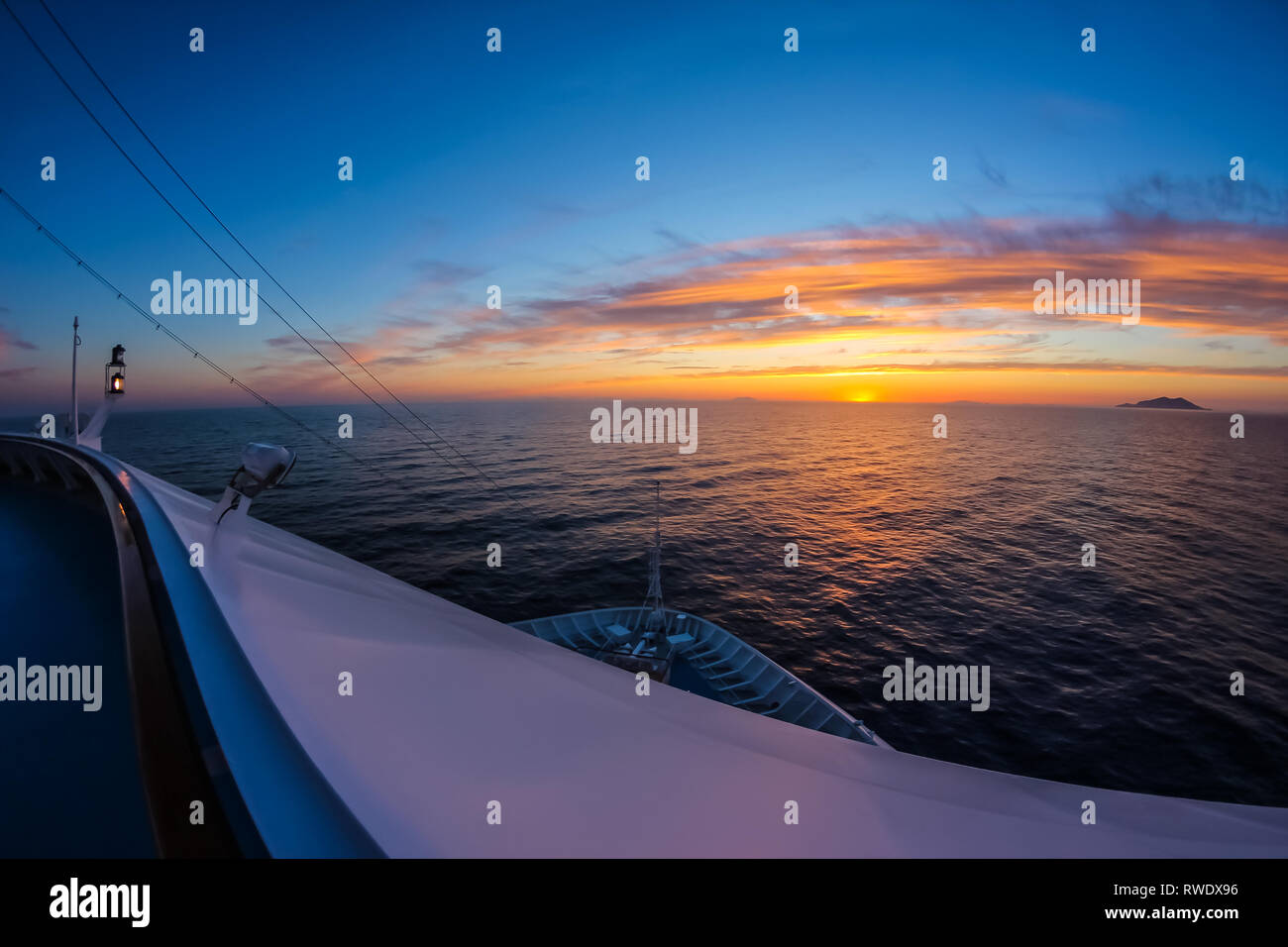 Open deck of a cruise ship sailing into the sunset with amazing colors ...