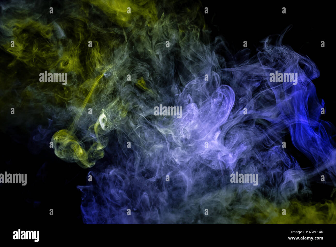 Dense multicolored smoke of blue and green colors on a black isolated ...