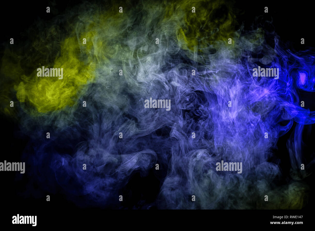 Dense multicolored smoke of blue and green colors on a black isolated ...