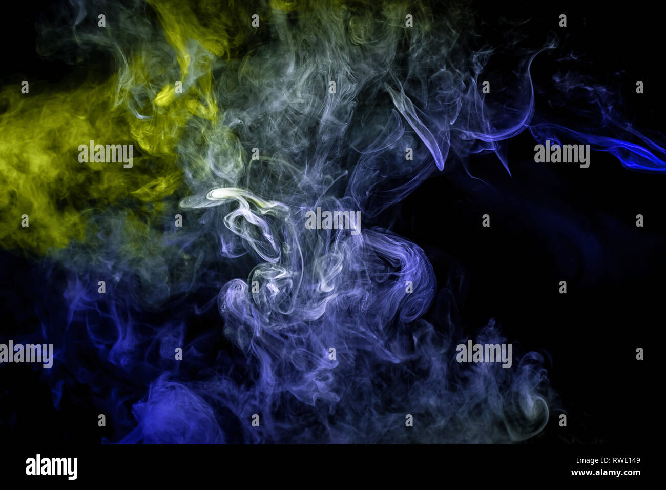 Dense multicolored smoke of blue and green colors on a black isolated ...