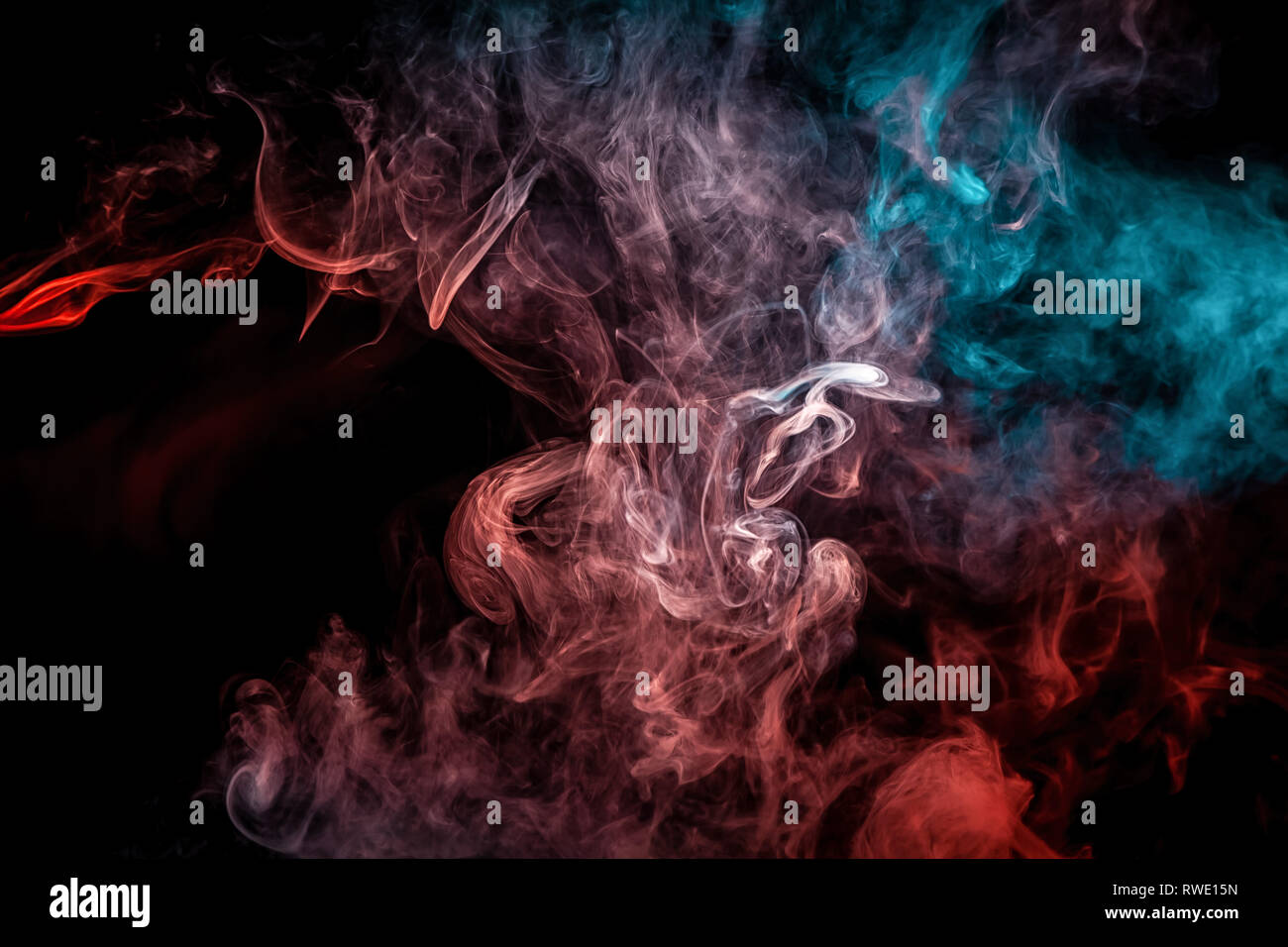 Dense multicolored smoke of blue and red colors on a black isolated ...