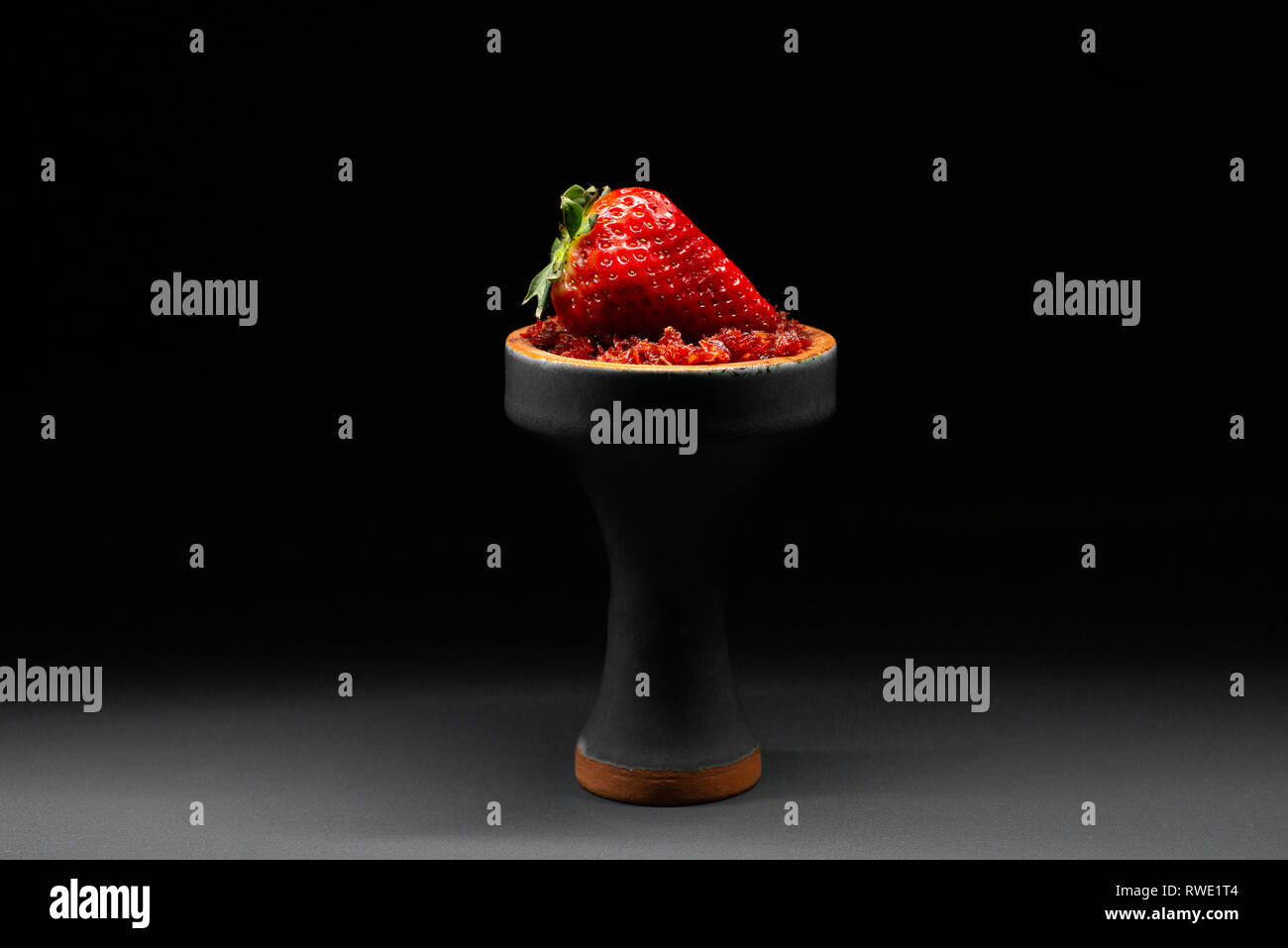 Hookah head with fruit on it decorated with exhaled smoke on black ...