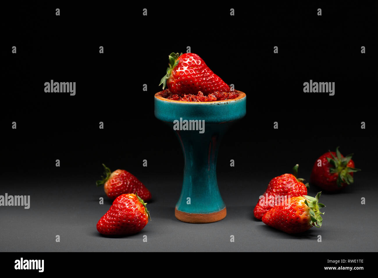 Hookah head with fruit on it decorated with exhaled smoke on black ...