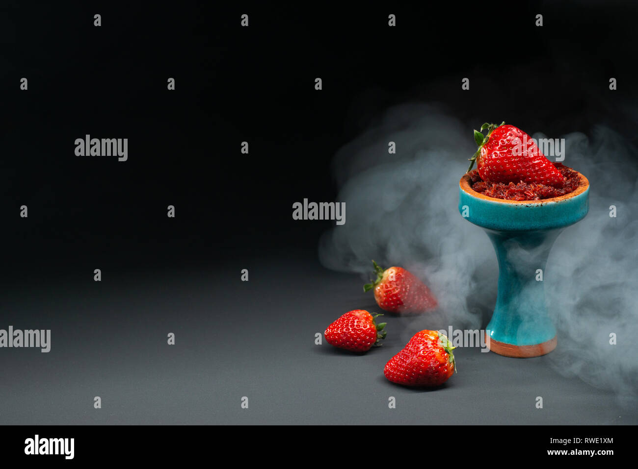 Hookah head with fruit on it decorated with exhaled smoke on black ...