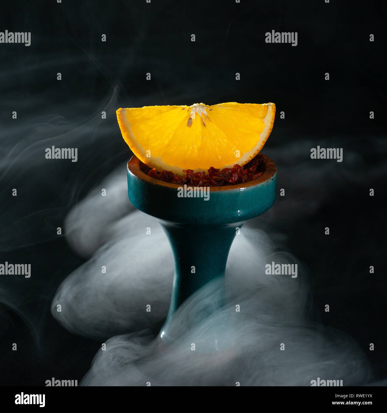 Hookah head with fruit on it decorated with exhaled smoke on black ...