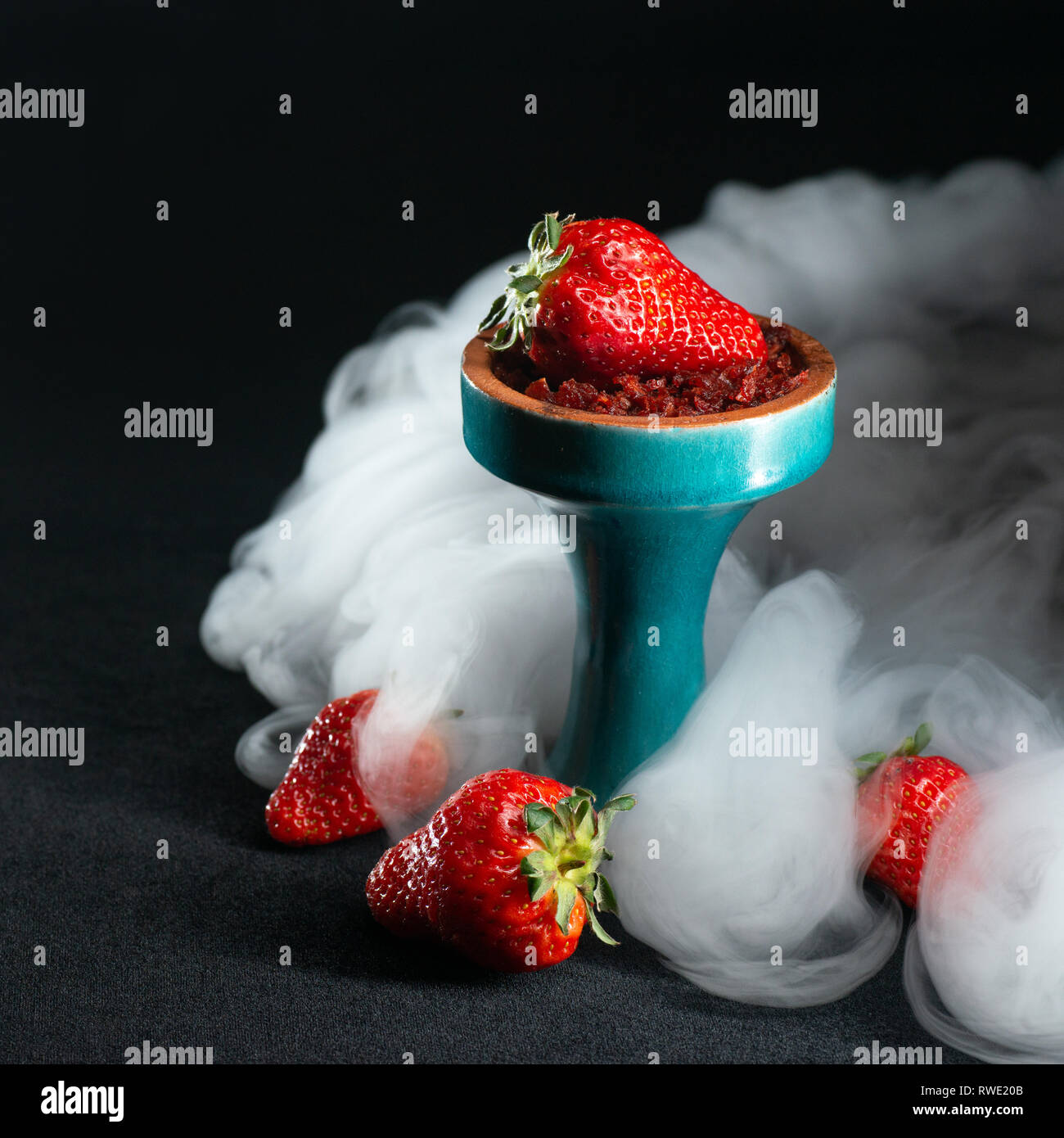 Hookah head with fruit on it decorated with exhaled smoke on black ...