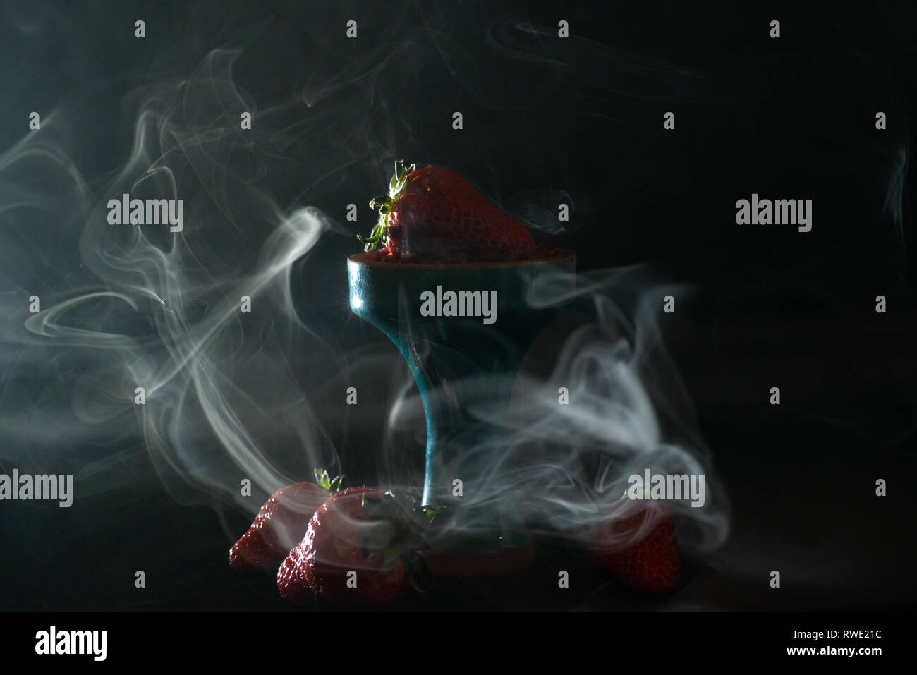 Hookah head with fruit on it decorated with exhaled smoke on black ...