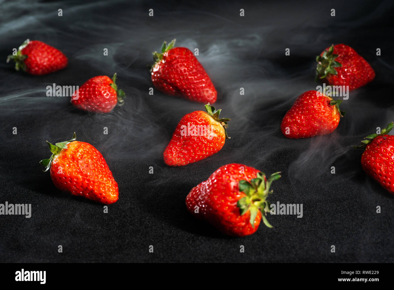 Stawberry fruits covered with exhaled smoke on black background Stock ...