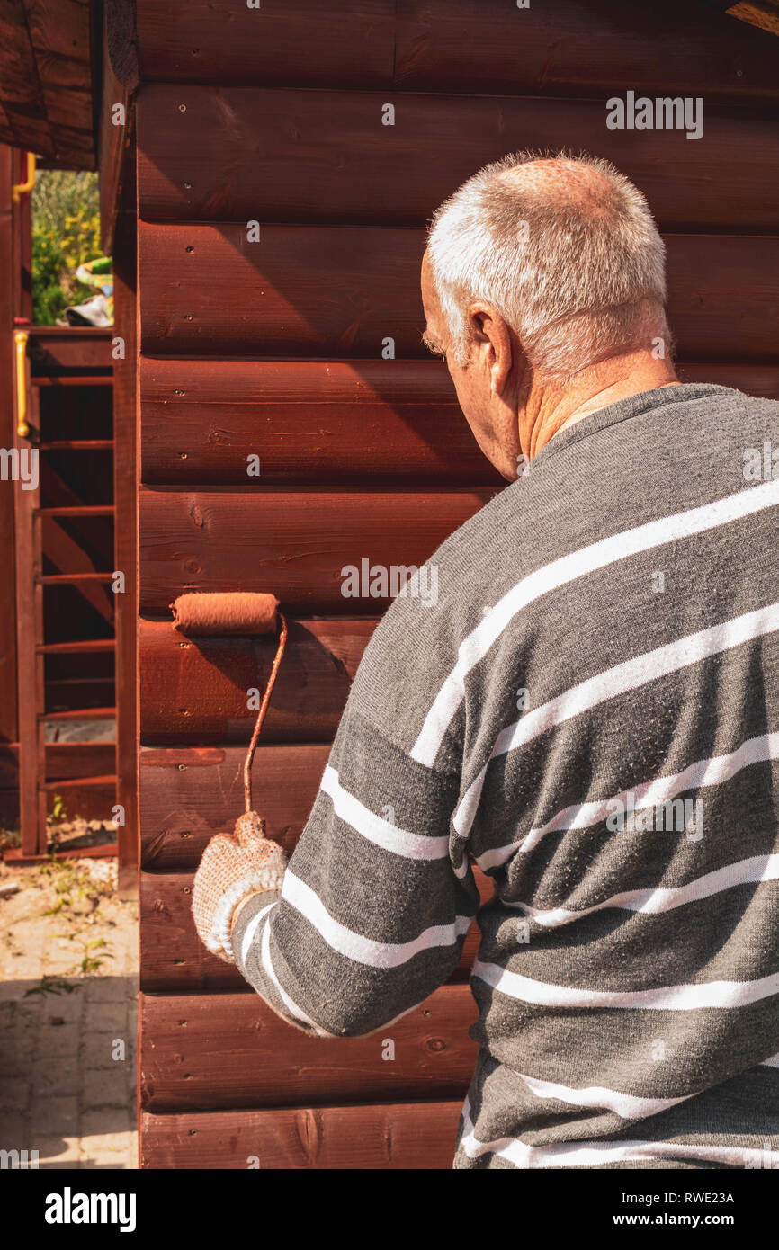 old man painter with paintbrush painting house wood wall Stock Photo ...