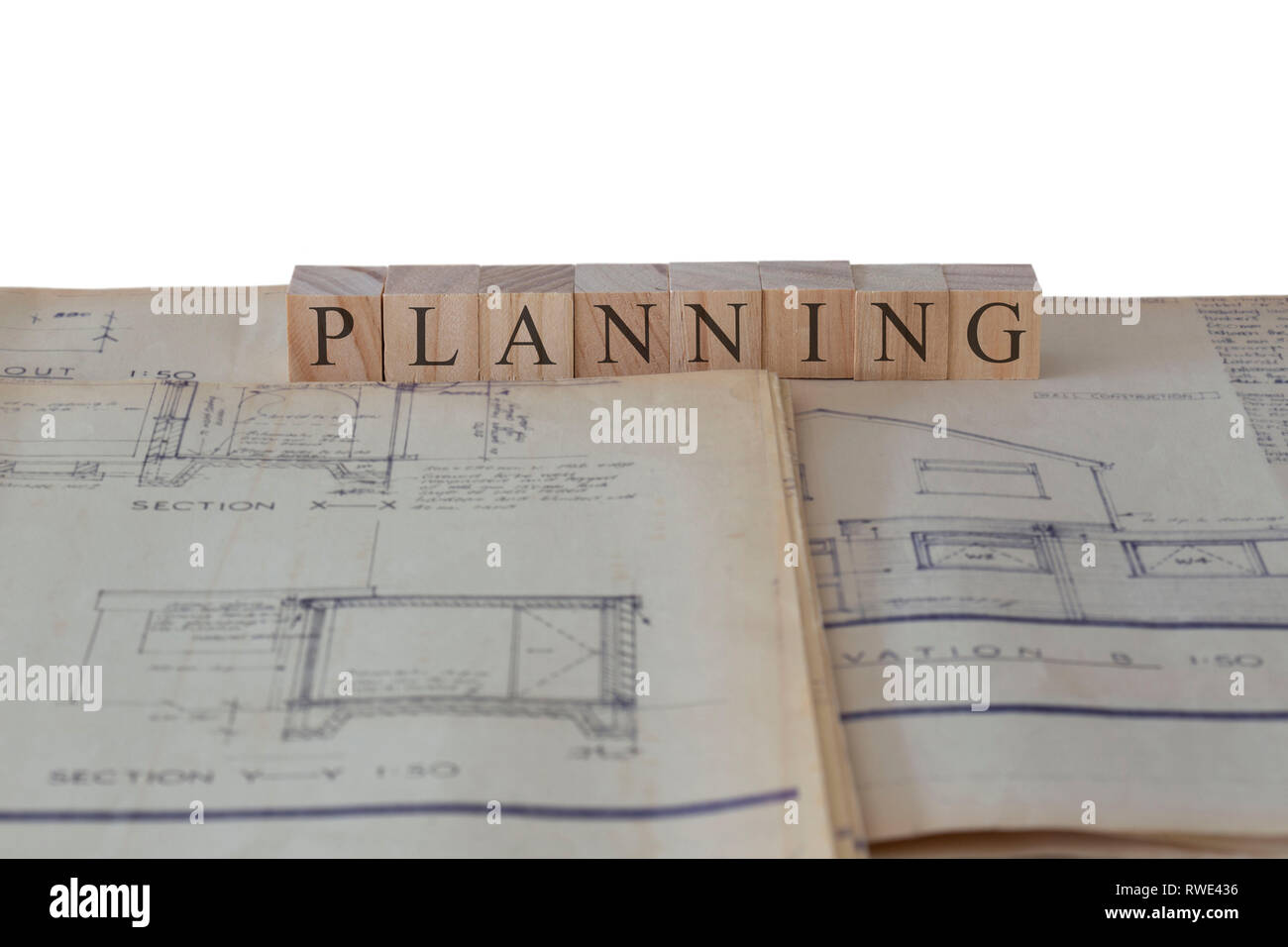 Planning written on wooden blocks on house extension building plans ...