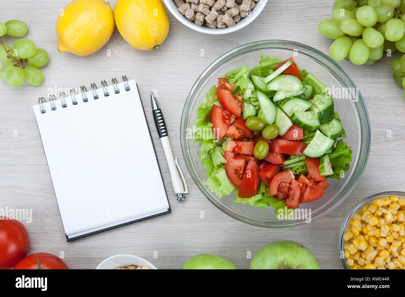 notebook with a diet plan with fresh vegetables and fruits and a side ...