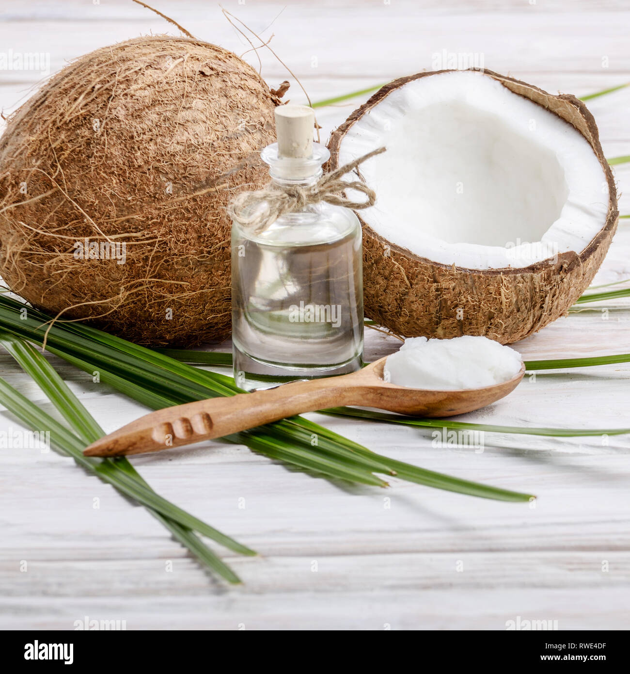 Coconut shell pieces and palm leaves on white wooden table Stock Photo ...