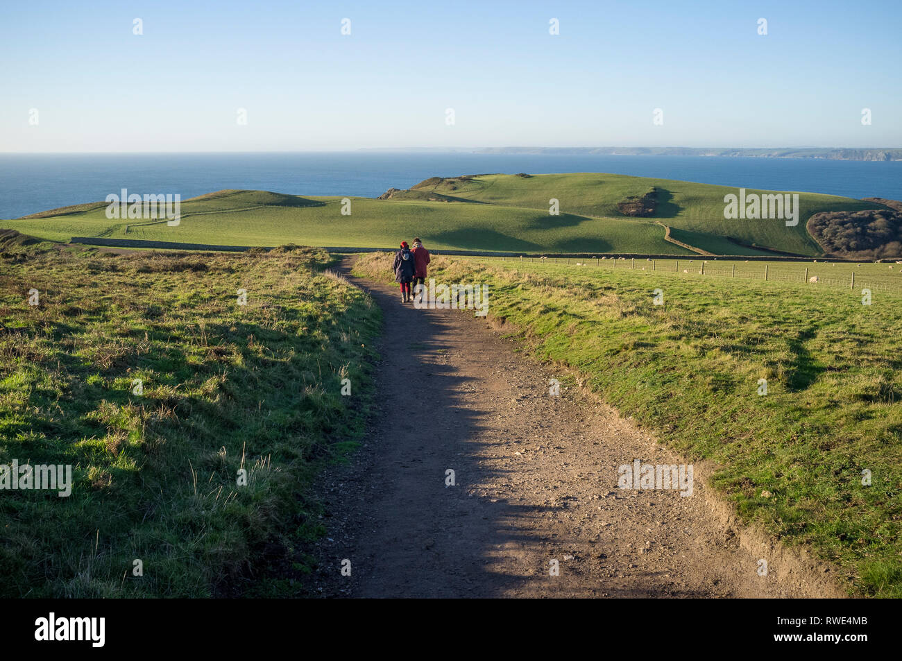 Friends walking along the headland of Bolt Tail, a spectacular coastal ...