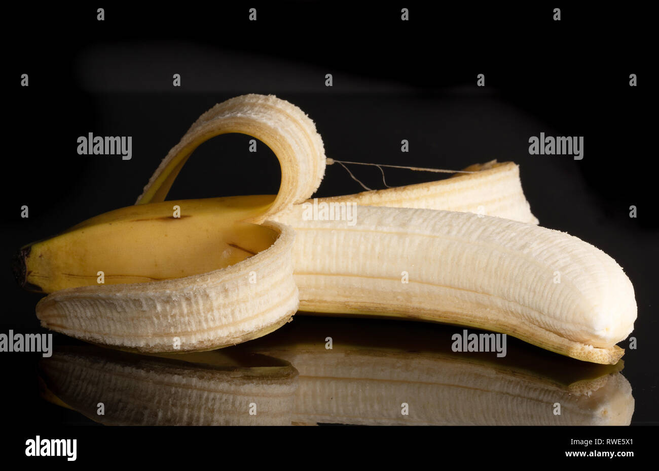 Banana on a black background with the mirror reflection. A modern ...