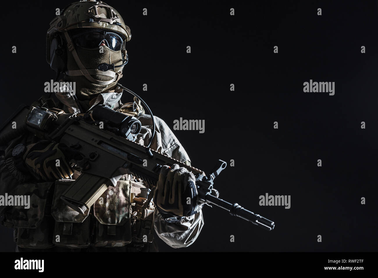 Dark contrast studio shot of Army soldier holding assault rifle Stock ...