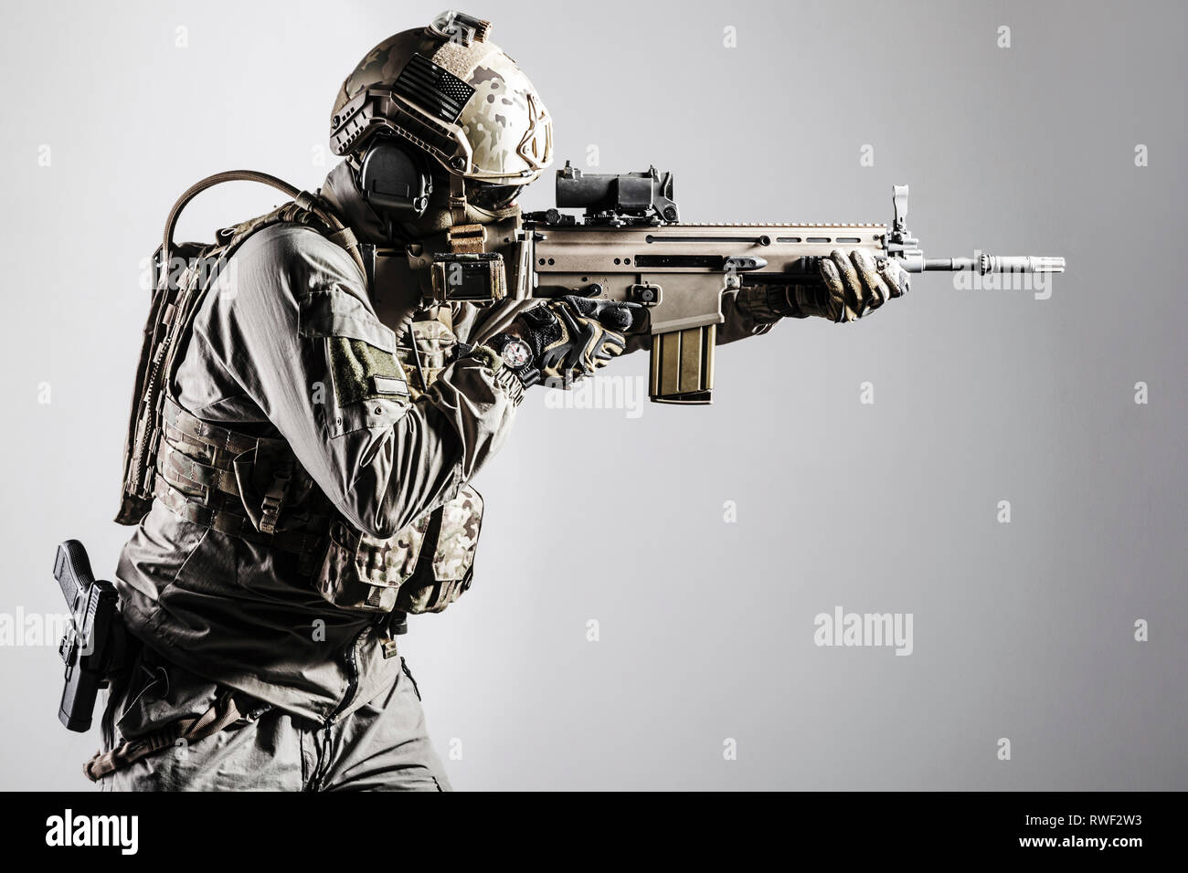 Army soldier in Protective Combat Uniform shooting an assault rifle ...