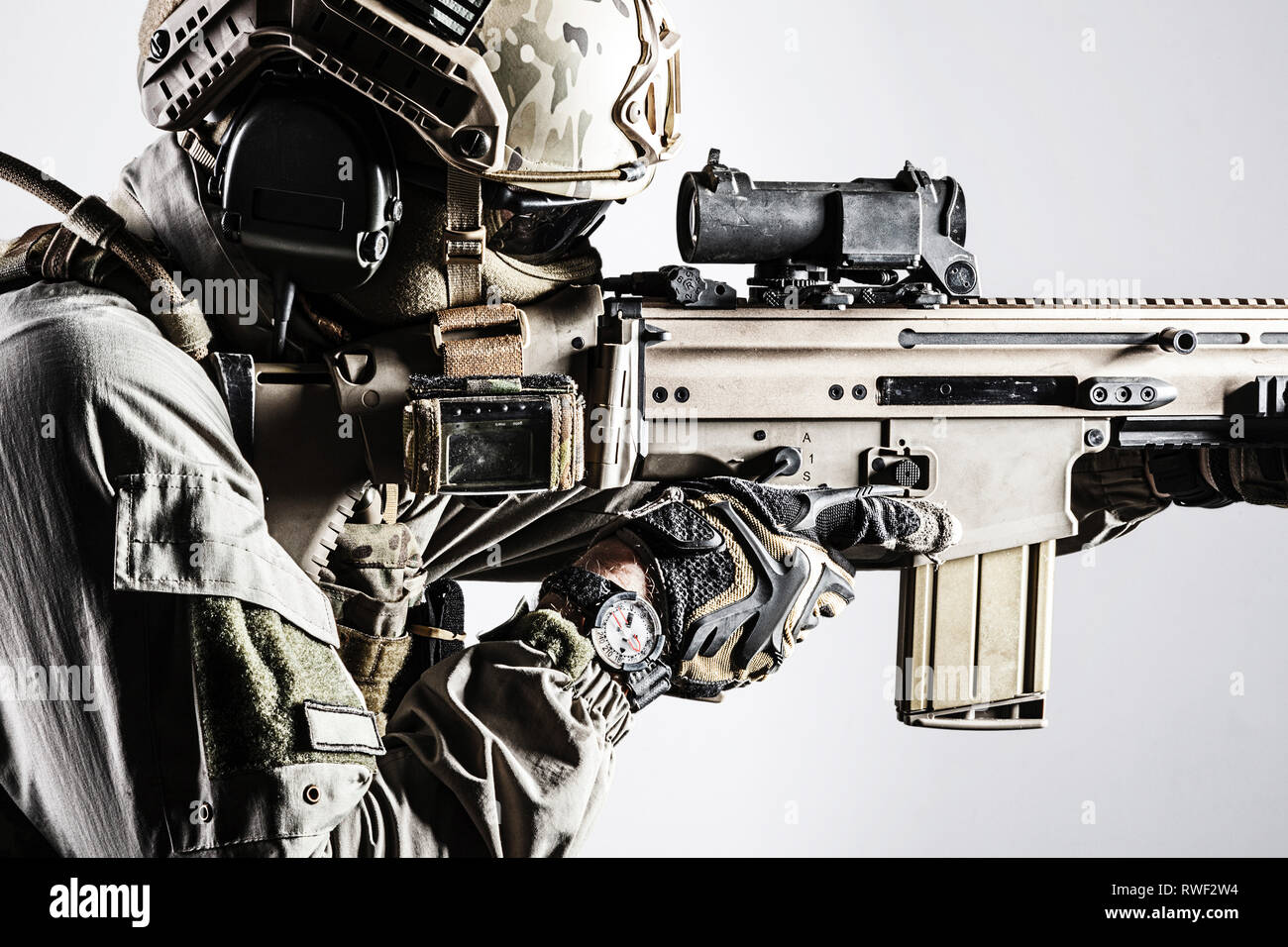 Army soldier in Protective Combat Uniform shooting an assault rifle ...