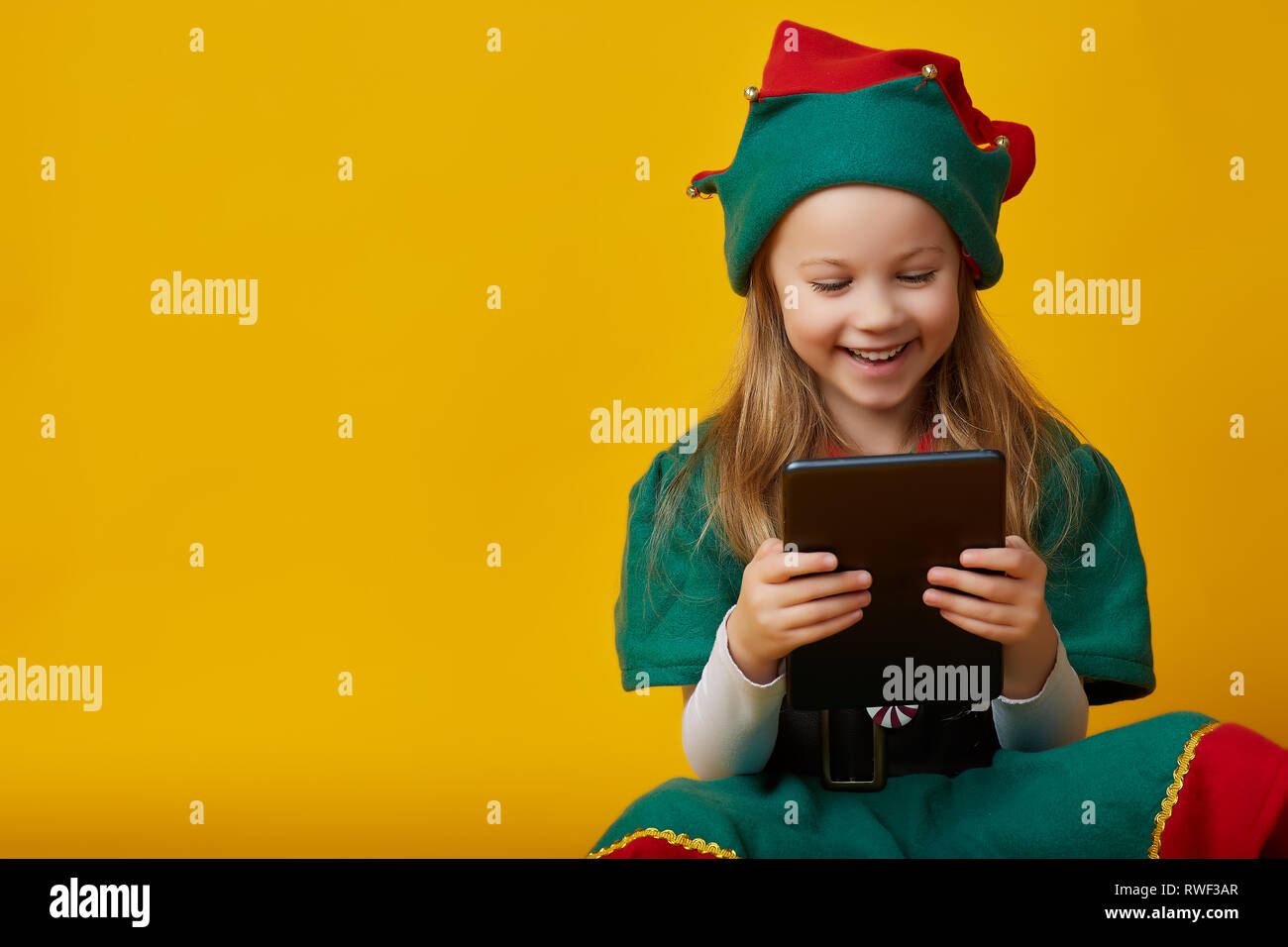 Portrait of a cheerful happy European little girl in elf costume ...