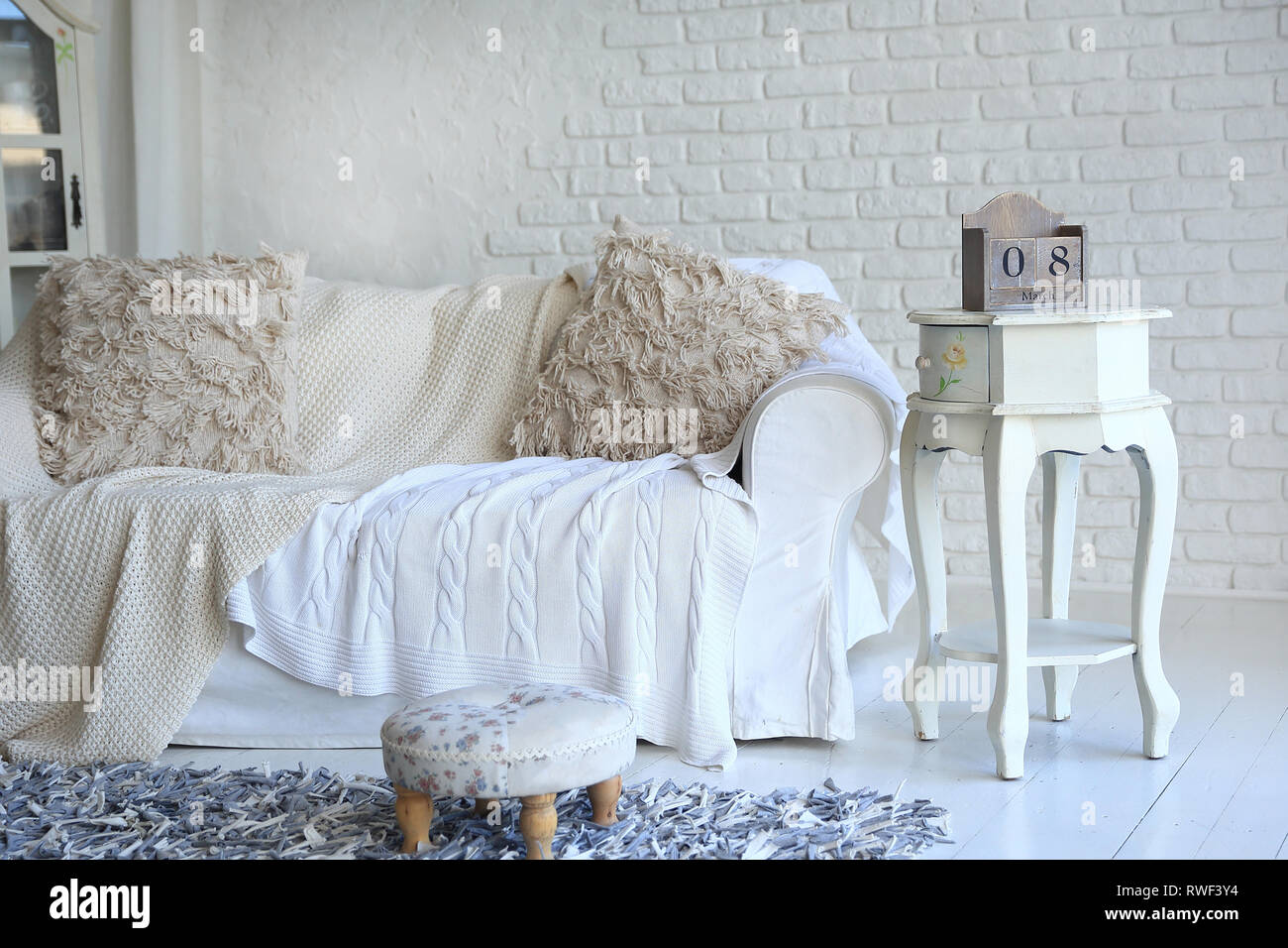 white sofa and nightstand with changeover calendar in a stylish living ...