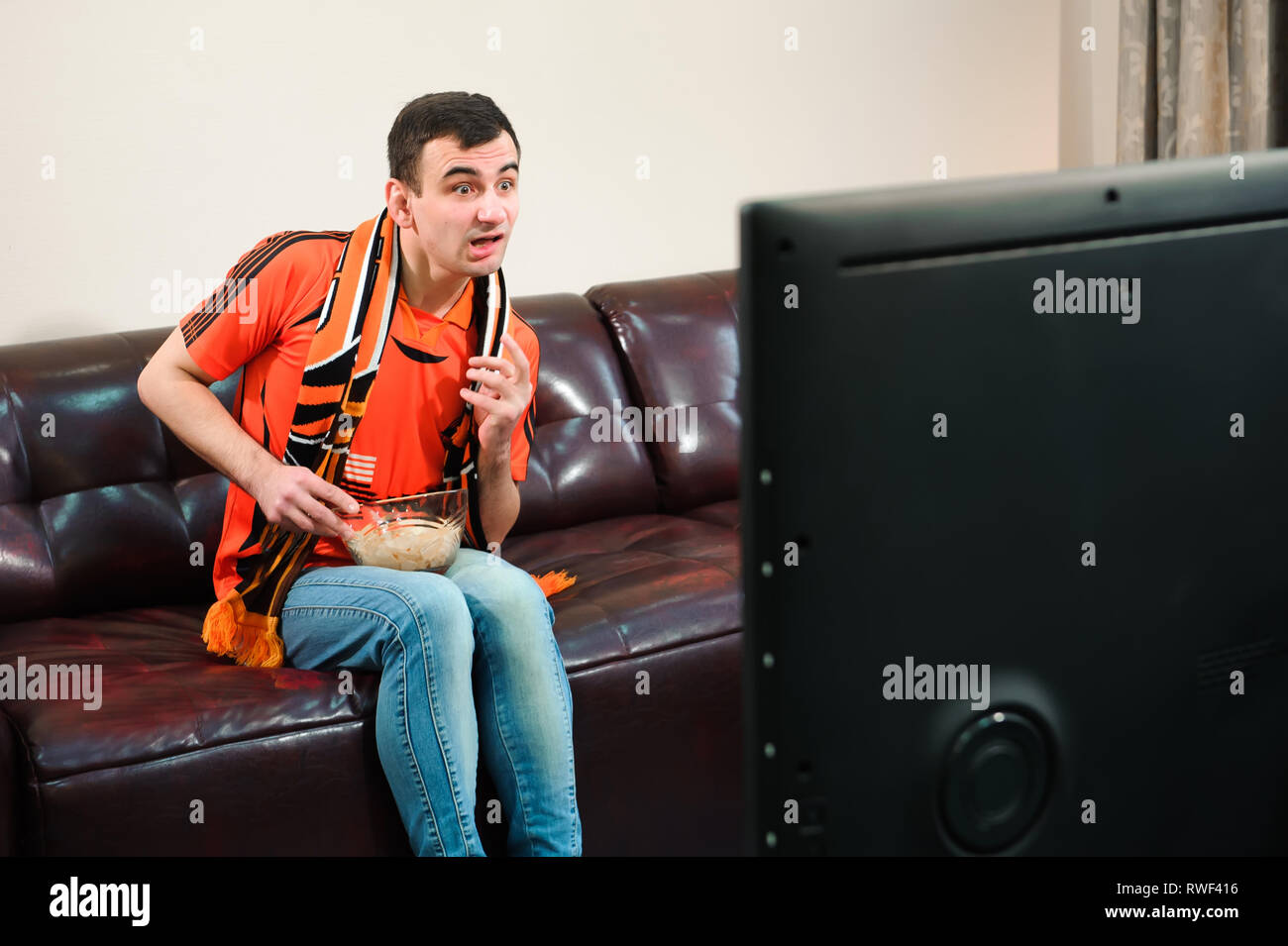 American friends watching football eating hi-res stock photography and ...