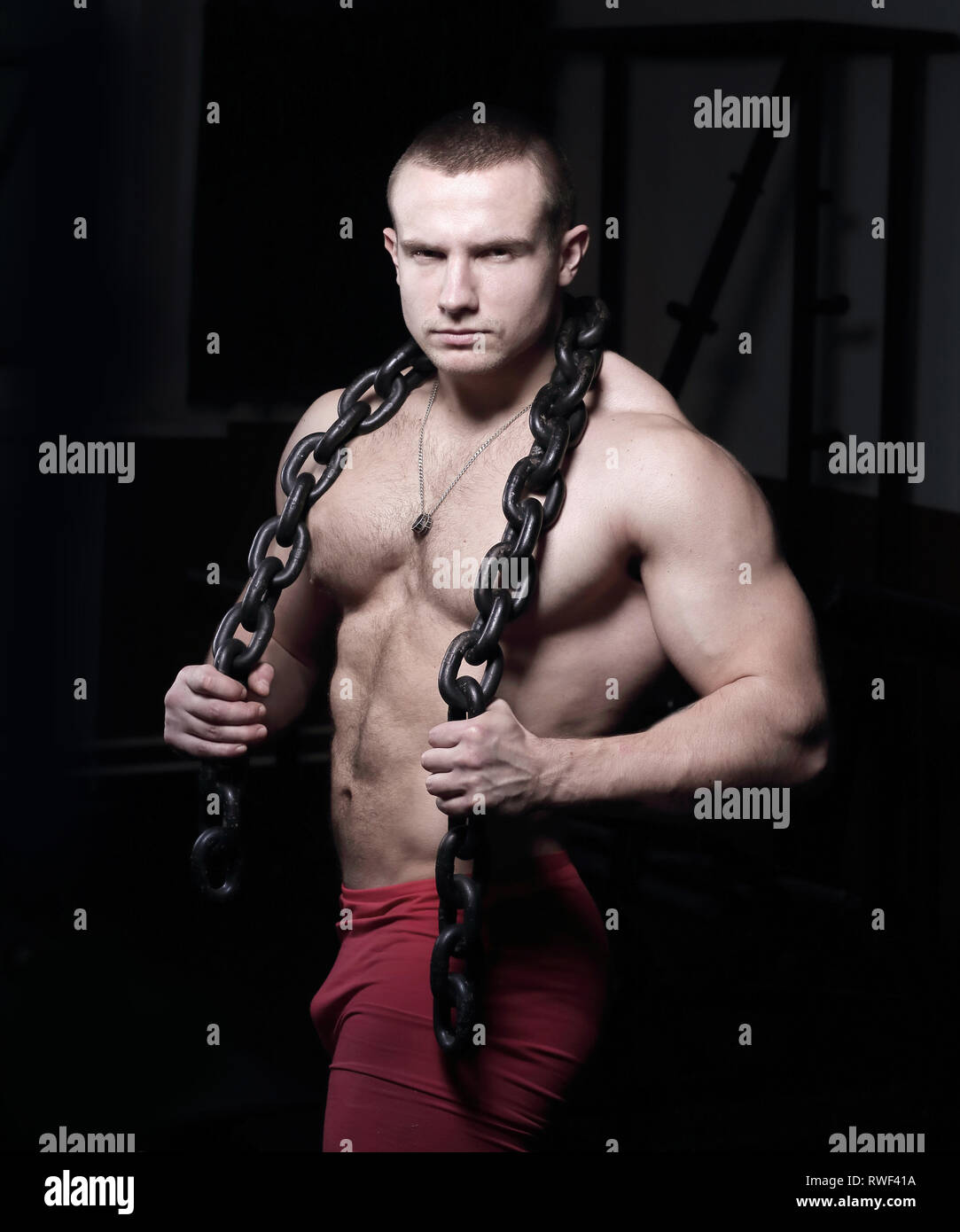 portrait of a handsome male bodybuilder with a chain around his neck ...