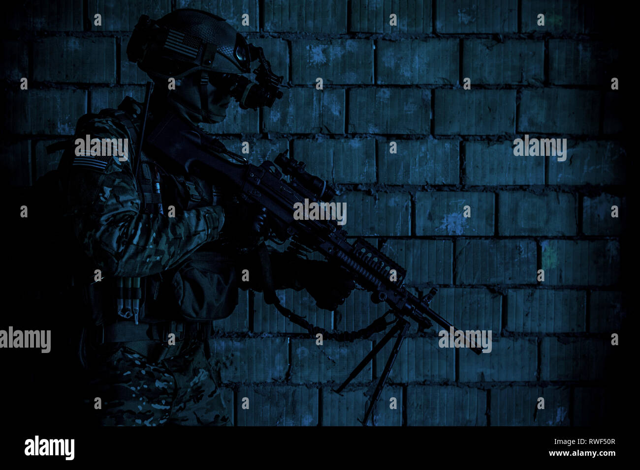 U.S. Army Ranger with machine gun and night vision goggles, moving ...