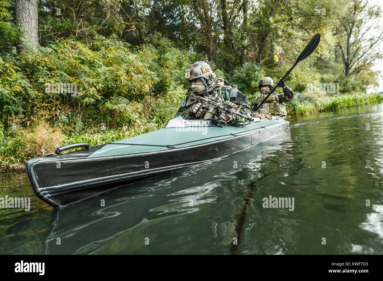 Special forces men paddling Army kayak across the river Stock Photo - Alamy