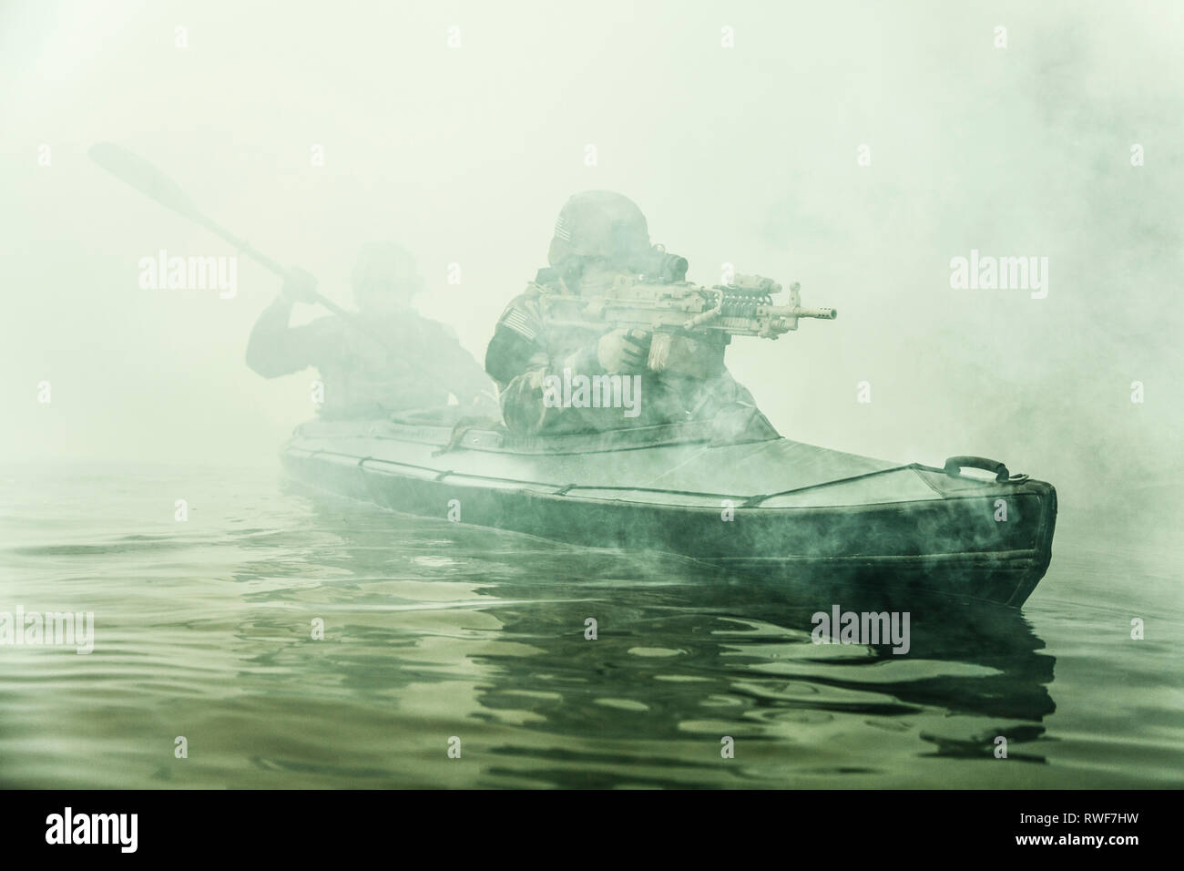 Special forces operator armed with machine gun, paddling Army kayak ...
