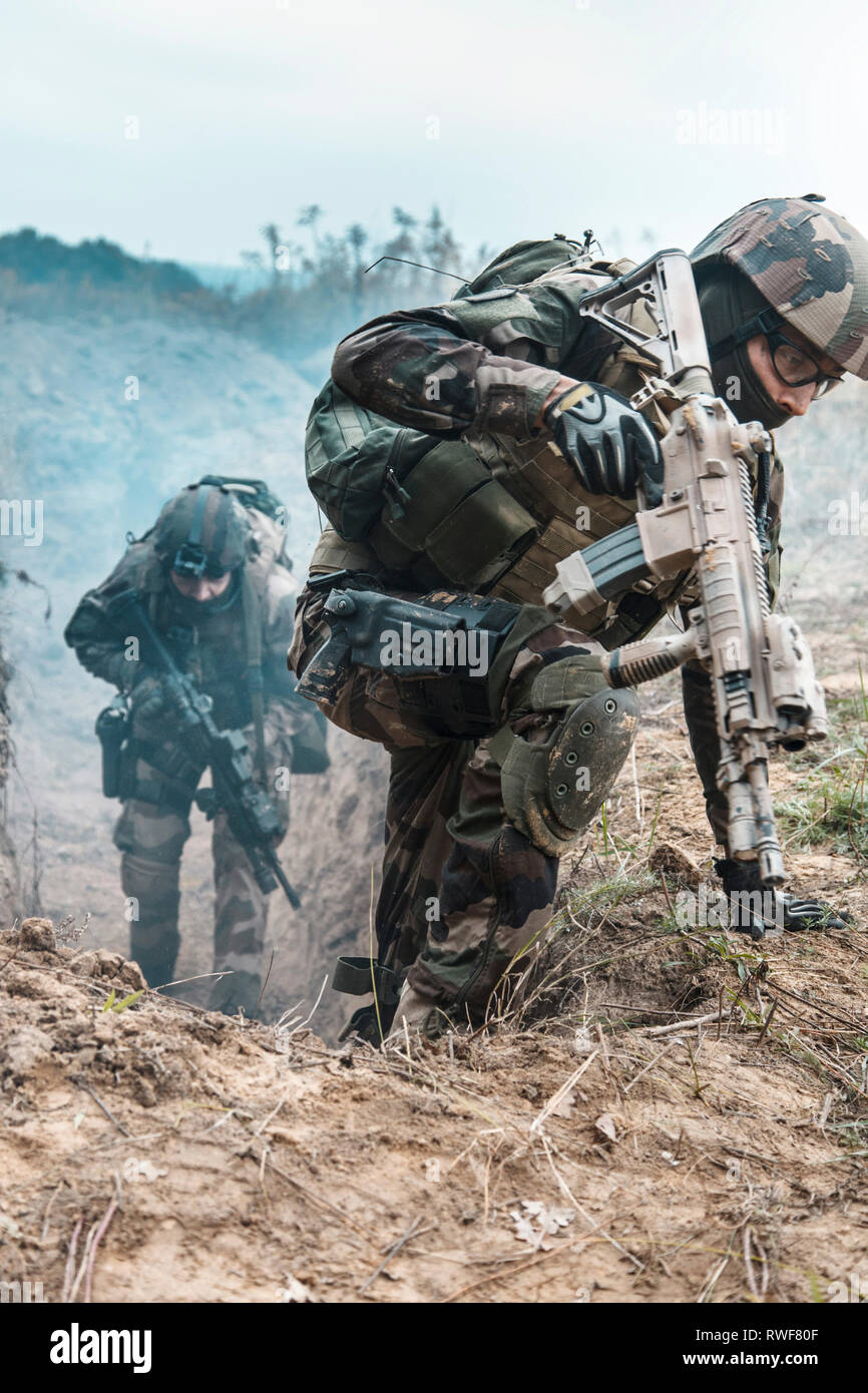 Two French paratroopers jumping out of enemy trench filled with ...
