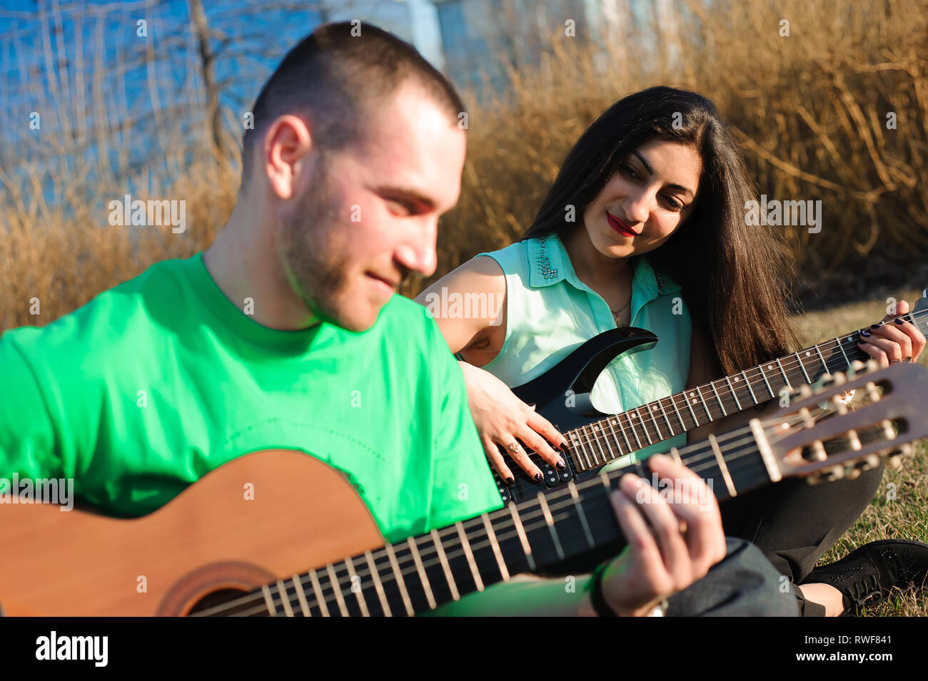 Romantic young couple portrait playing guitar under blue sky Stock ...