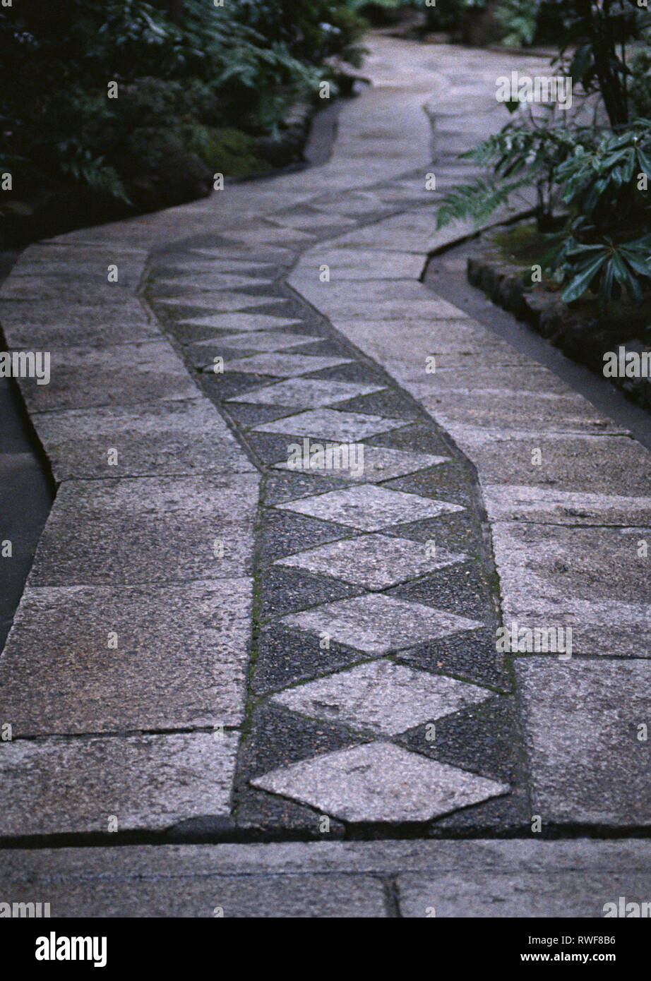Japanese outdoor garden pathway with green bushes and stone flooring ...