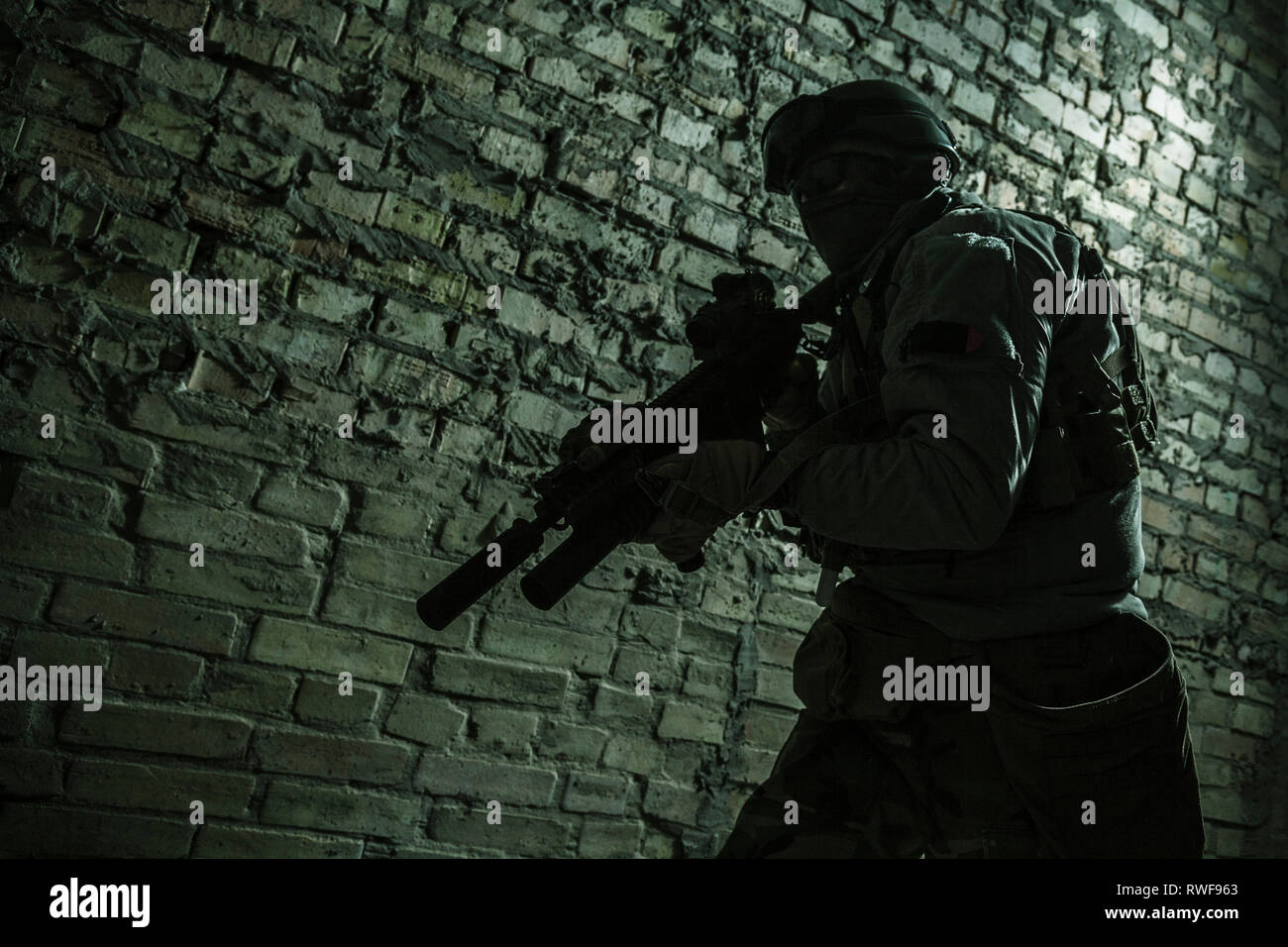 Special forces operator pointing weapon in the dark Stock Photo - Alamy