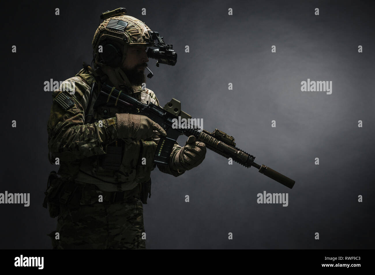 Bearded soldier in combat uniform with weapon, studio shot Stock Photo ...