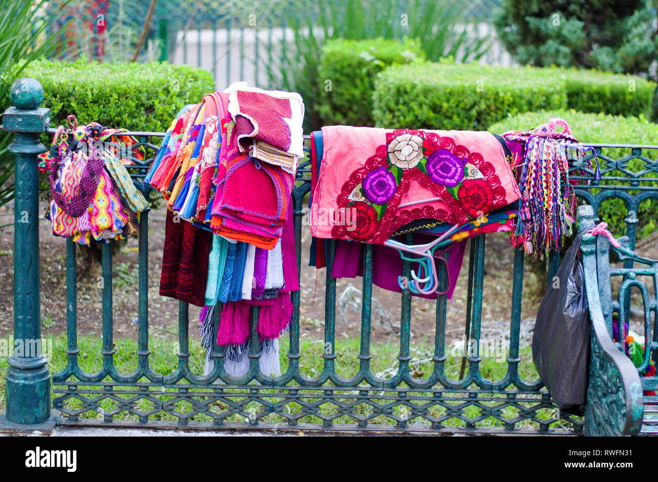Pile of colorful clothes over a fence Stock Photo - Alamy