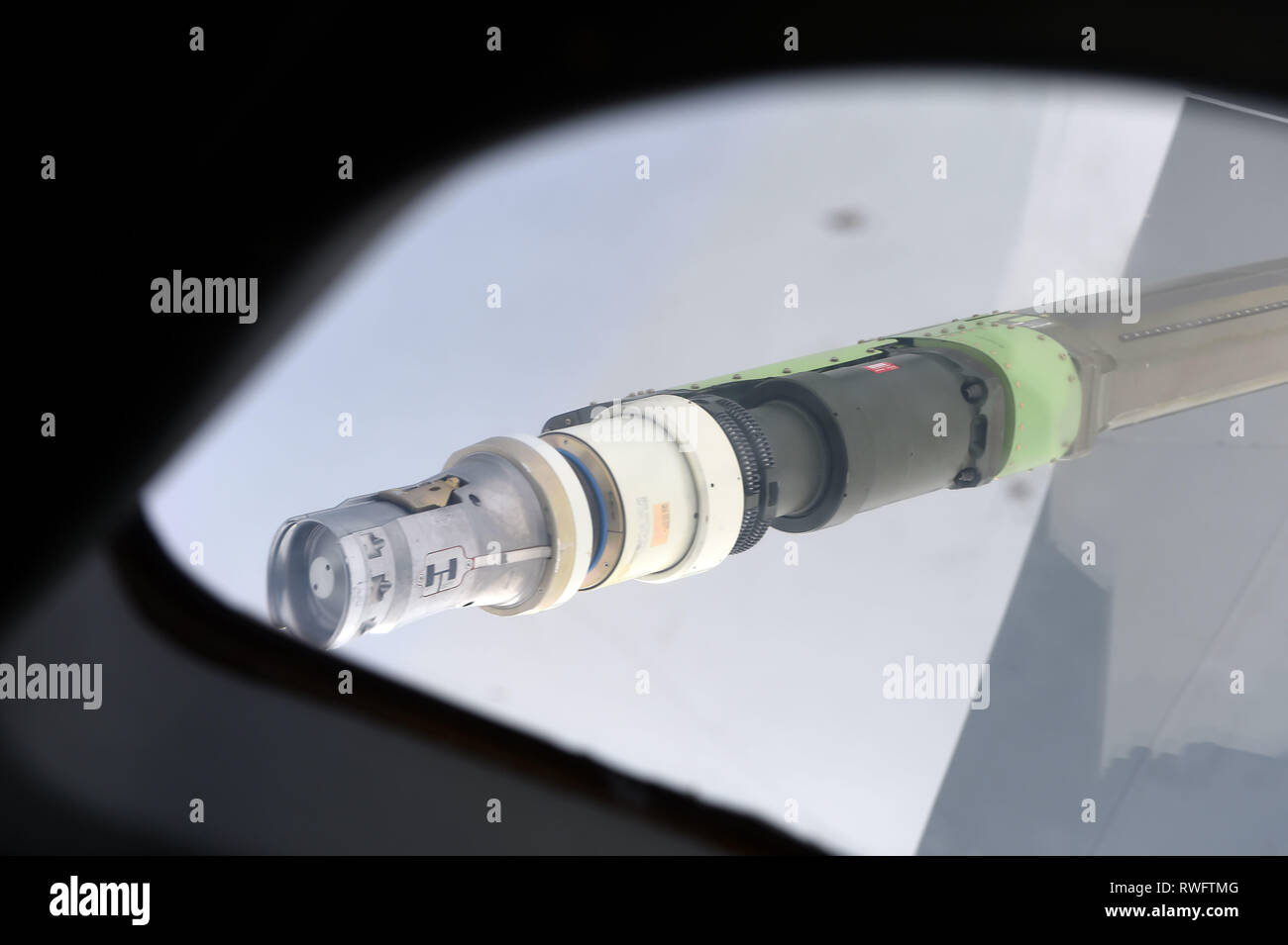 The refueling boom of a KC-46 Pegasus moves towards the universal ...